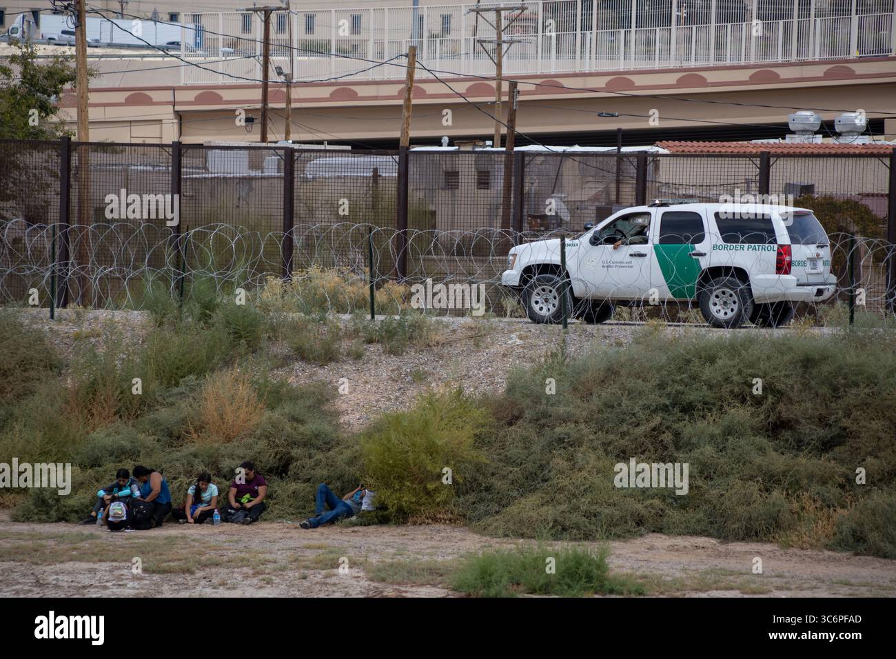 A group by barbed wire and a Border Patrol vehicle at Ciudad Juarez, a ...