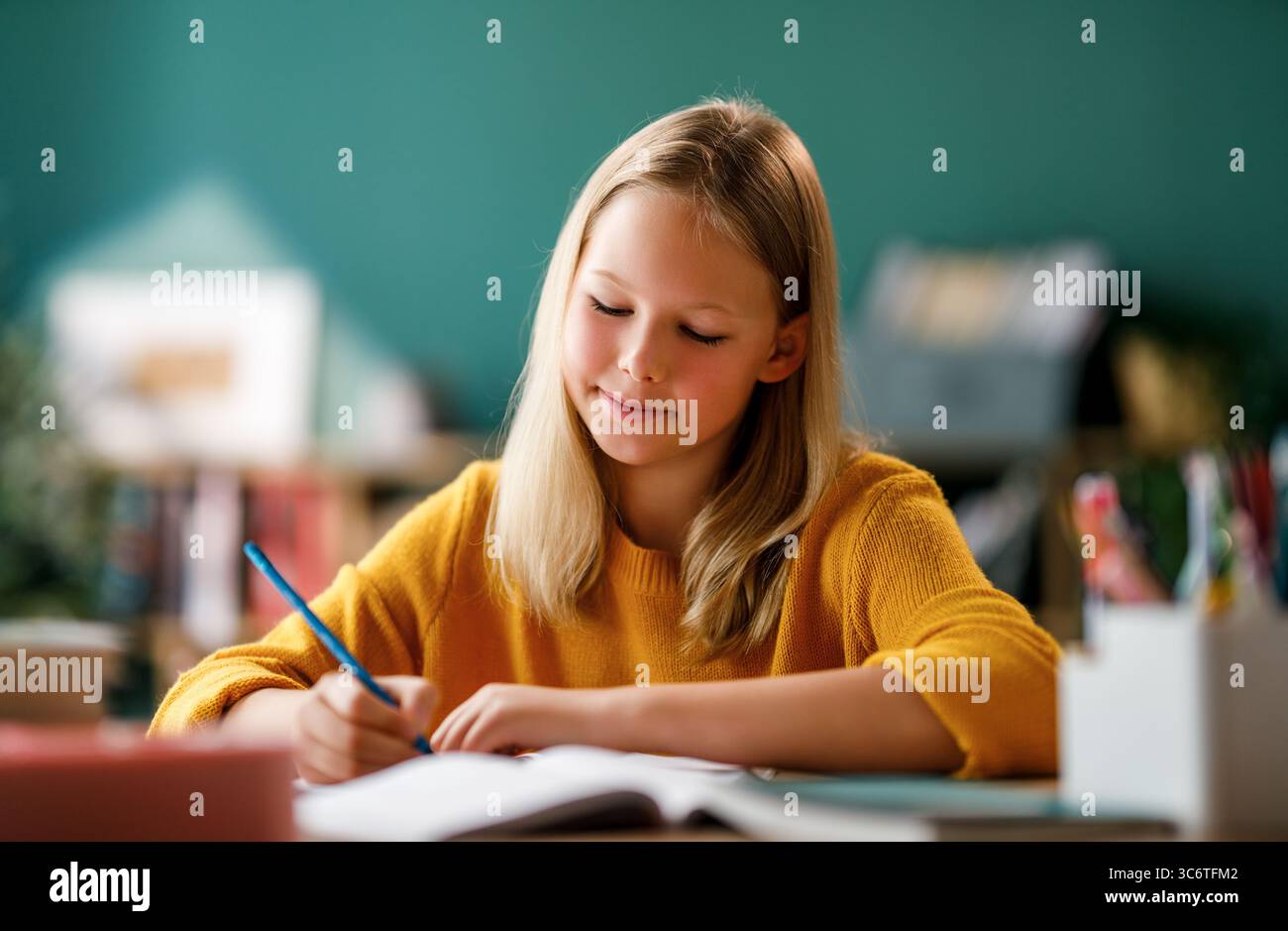 Happy kid at school. Child is learning in the class or doing homework ...