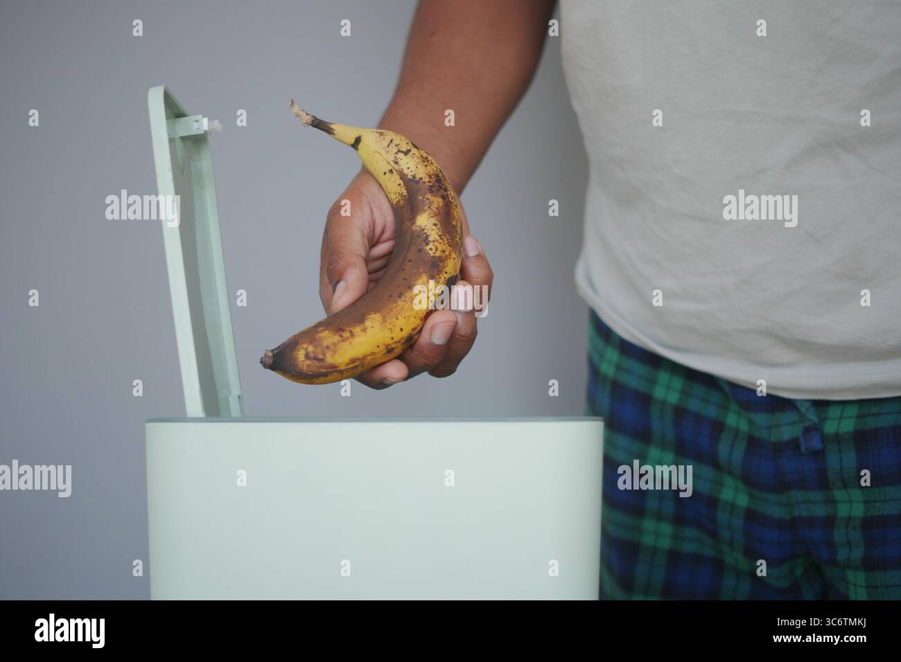 Disposing of a overripe banana in a trash bin Stock Photo - Alamy