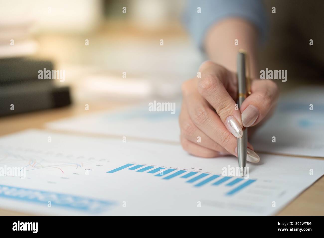Data Analysis. Woman reviewing financial graphs and charts with a pen ...