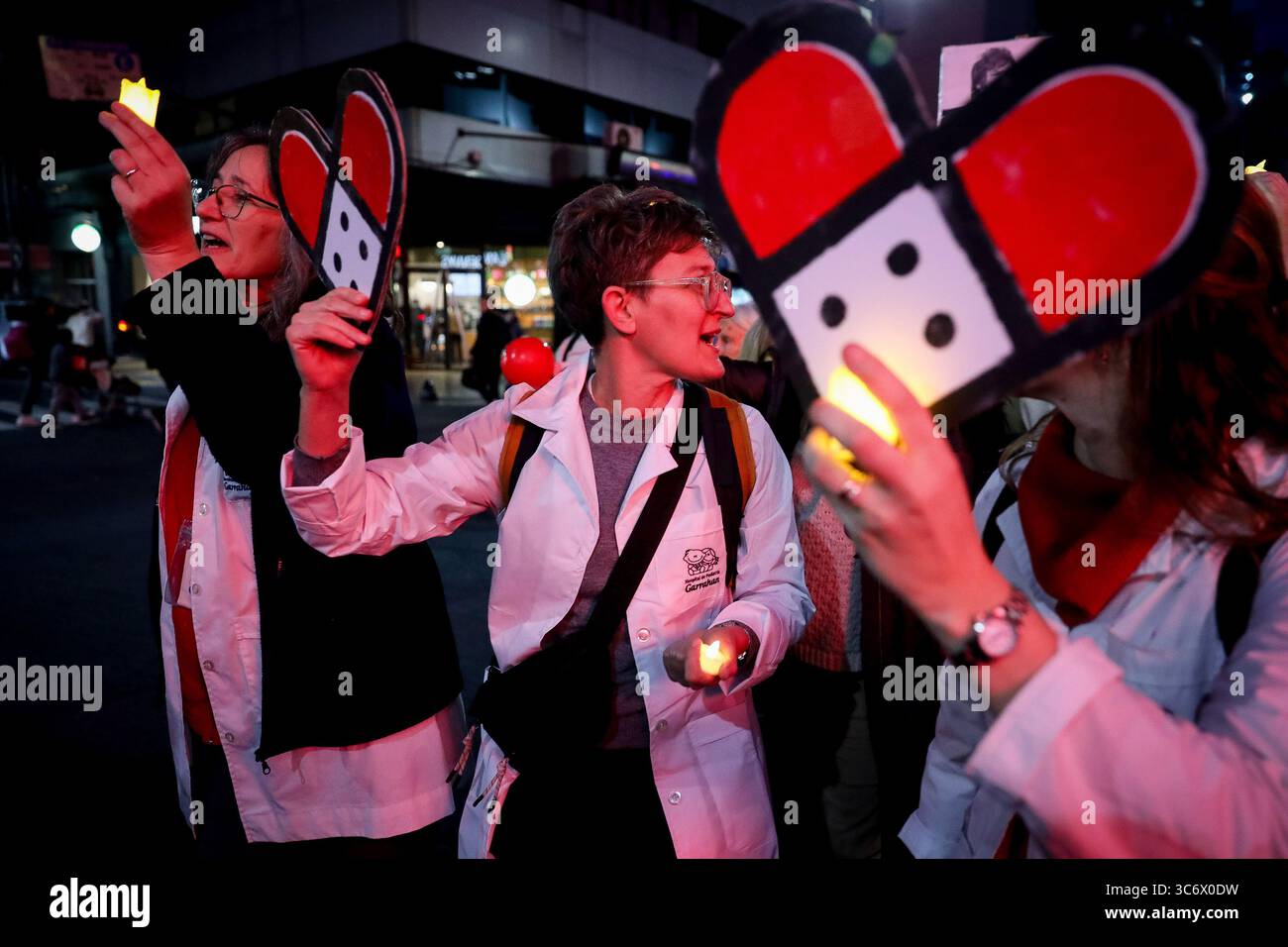 Protesters hold candles during the candlelight march in defense of the ...