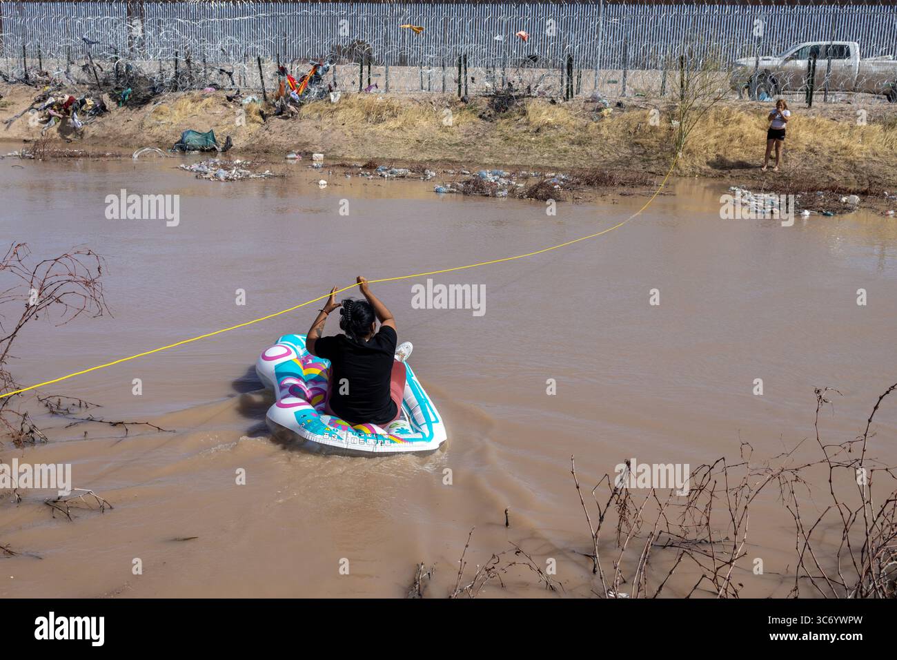 Migrant navigates muddy river at Ciudad Juarez border Stock Photo - Alamy