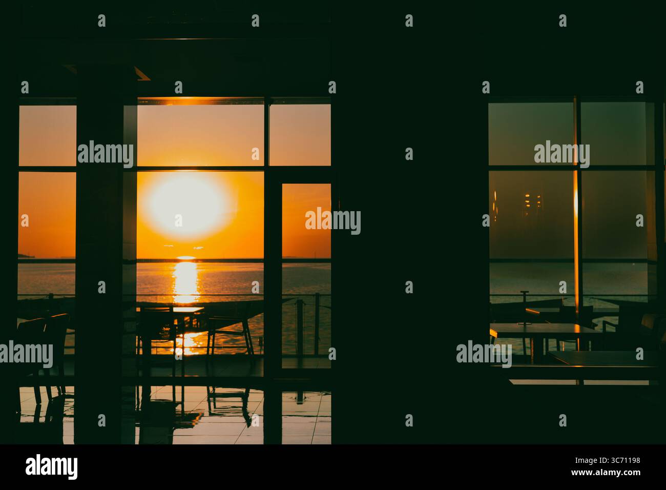 The huge sunset over the ocean creates a stunning view seen through a ...