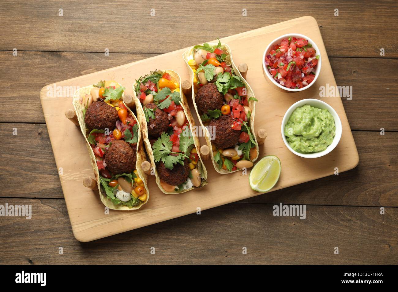 Tasty vegetarian tacos with falafel served with salsa and guacamole on ...