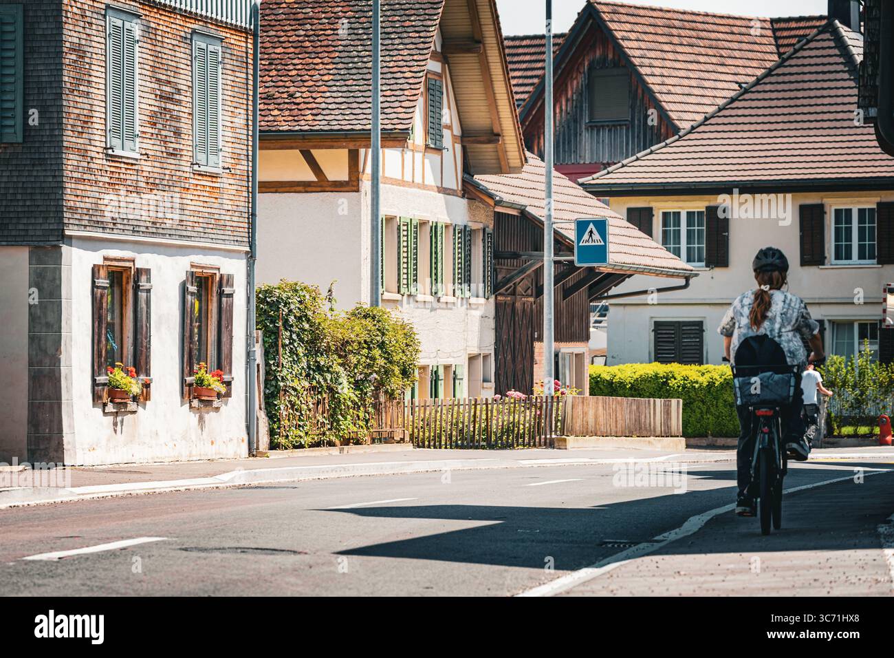 Cyclist rides through suburban street hi-res stock photography and ...