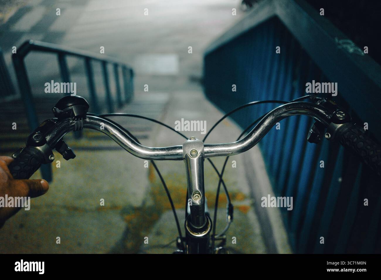 View of the bicycle handlebars on the bridge in front of the stairs ...