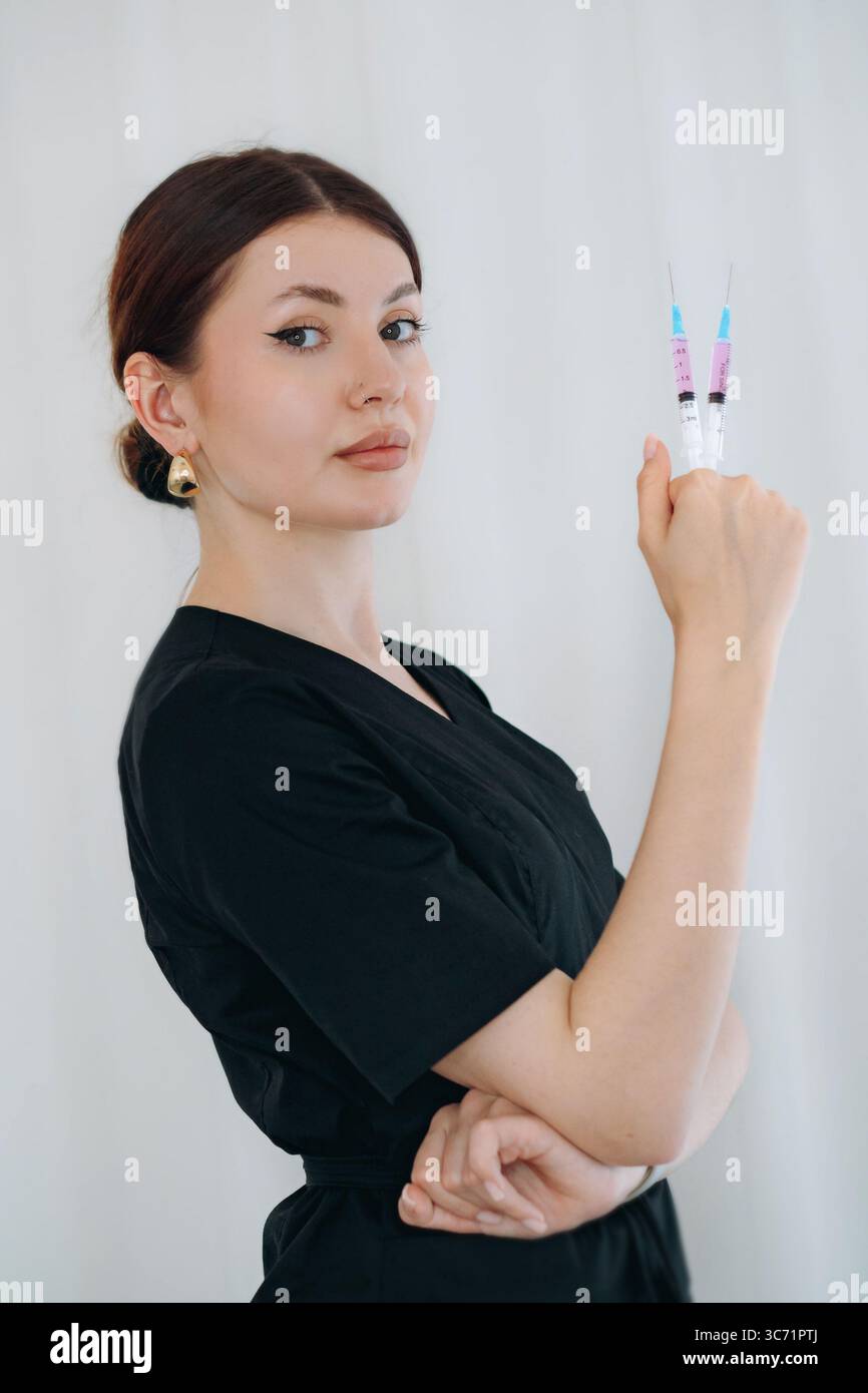 young woman aesthetician doctor wearing black medical suit holding ...