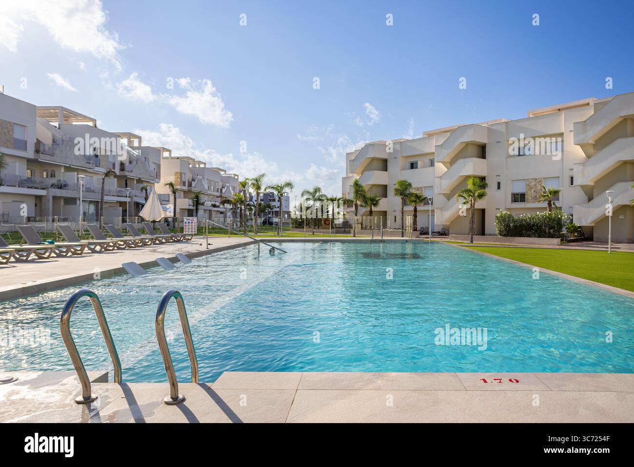 Inviting swimming pool with metal steps and underwater loungers ...