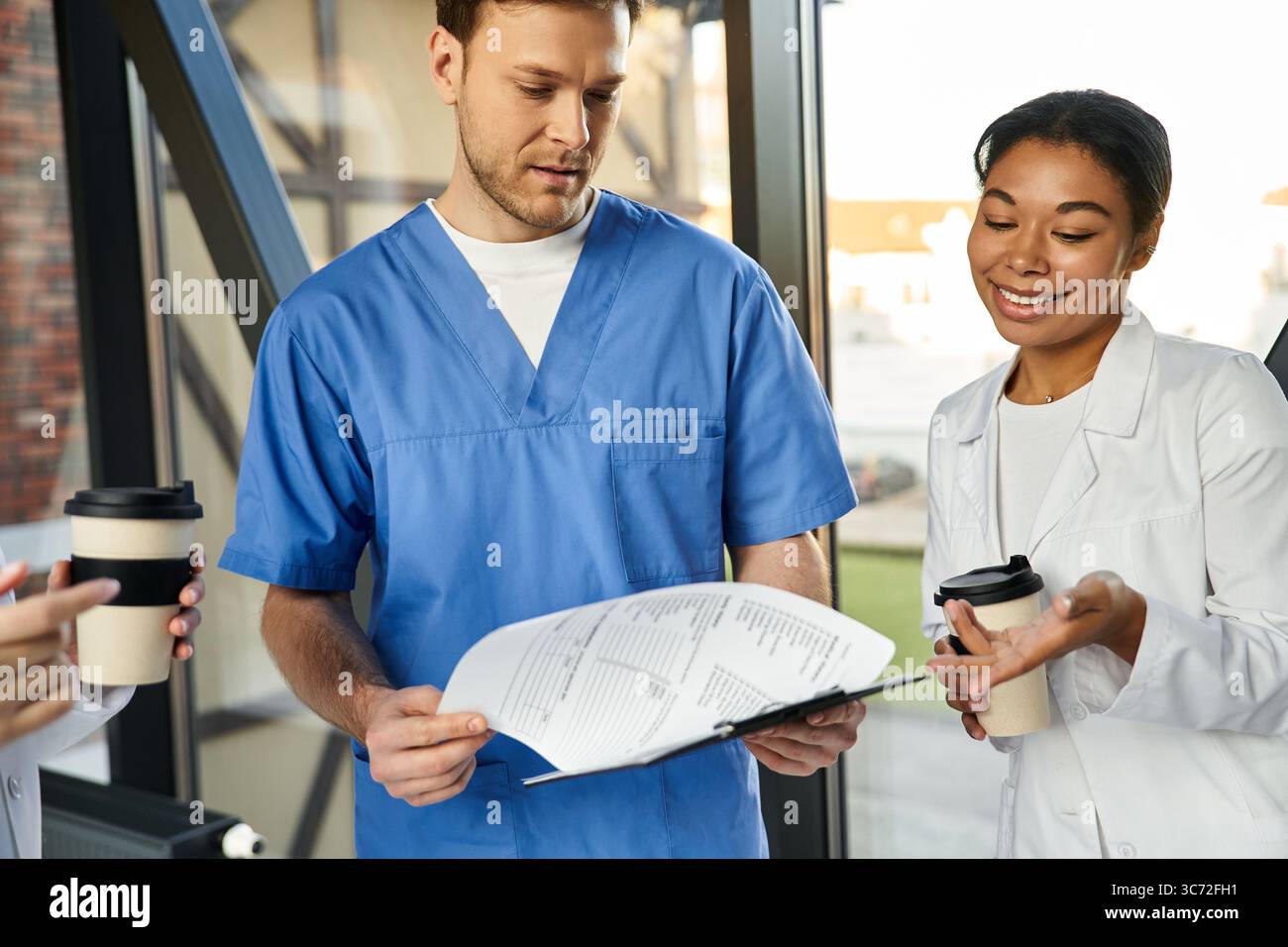 Three diverse medical professionals review patient information while ...