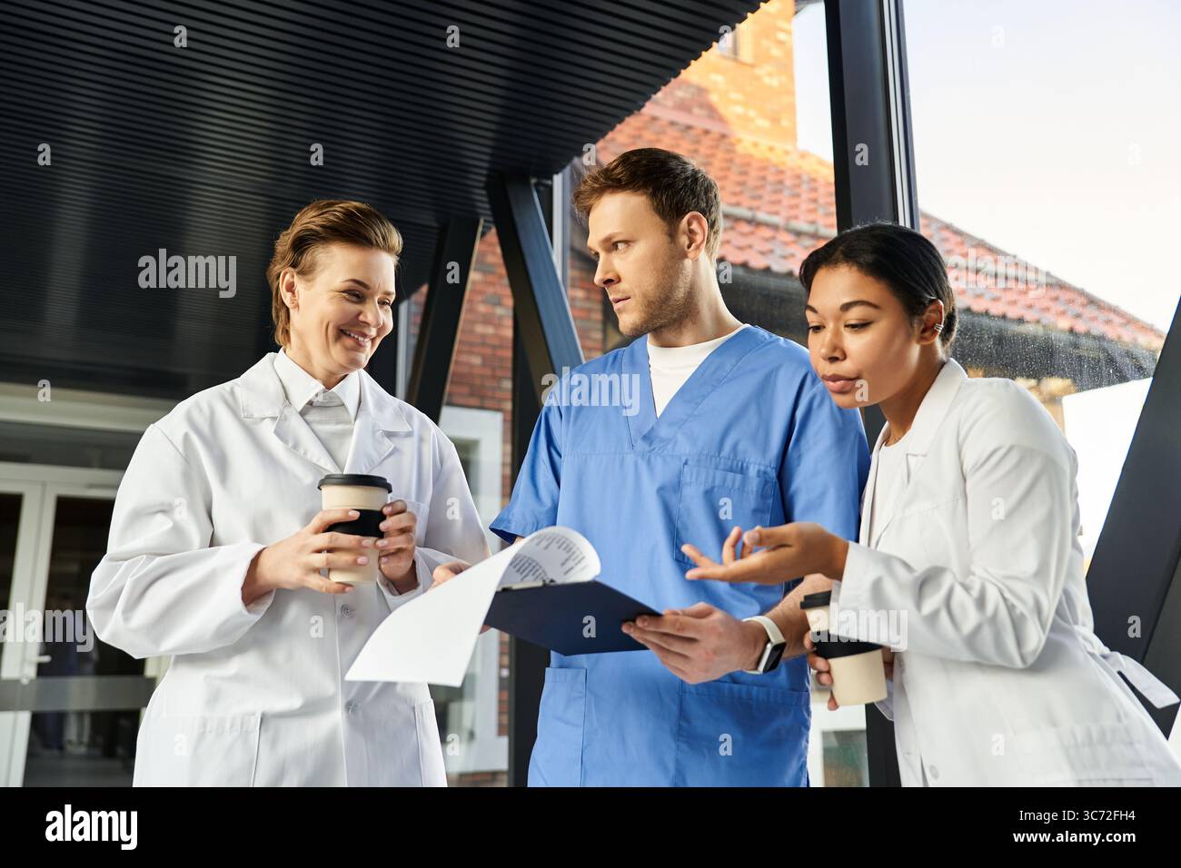 Three diverse medical experts collaborate in a modern hospital ...