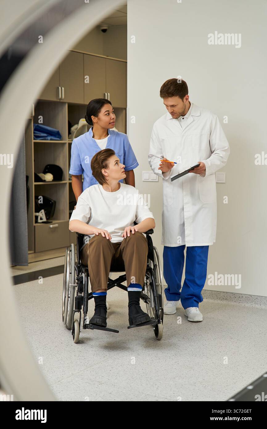 A skilled doctor and compassionate nurse assist a female patient in a ...