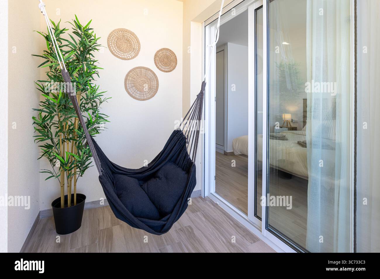 Cosy terrace corner with hanging hammock chair, bamboo plant, and ...