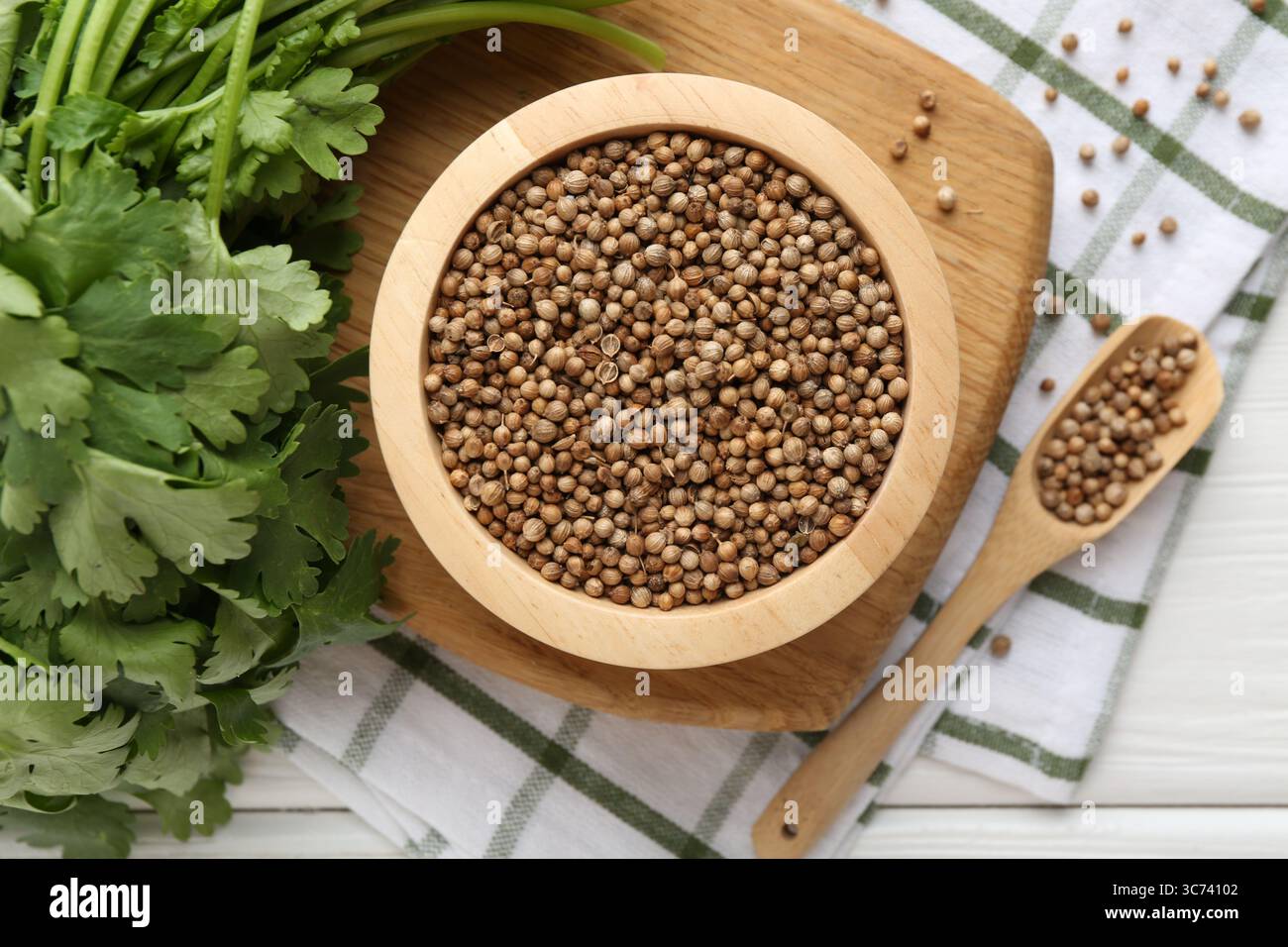 Coriander seeds and fresh cilantro on white wooden table, flat lay ...