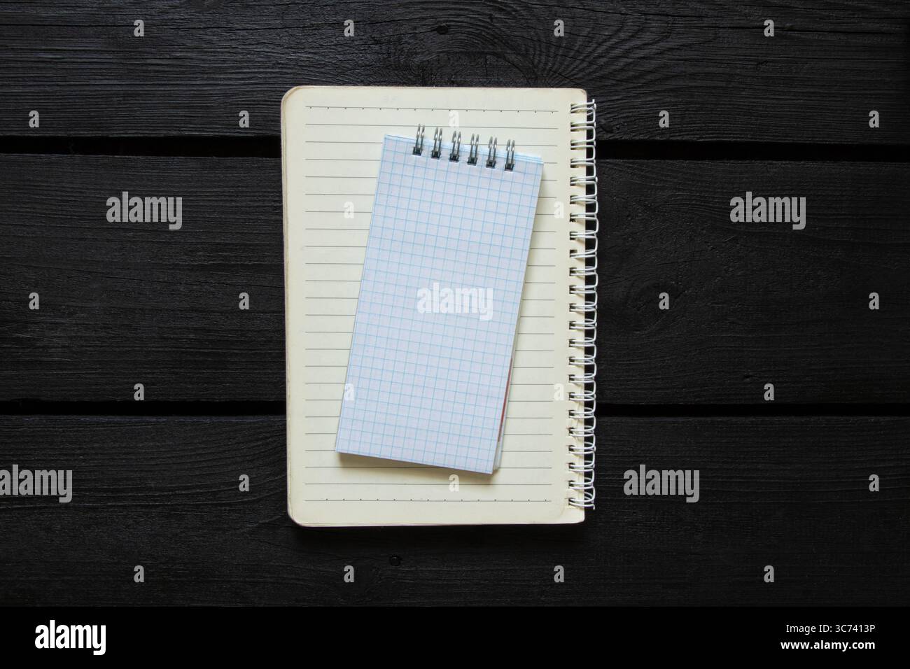 Open notebook in line with white checkered notebook on top, both on ...