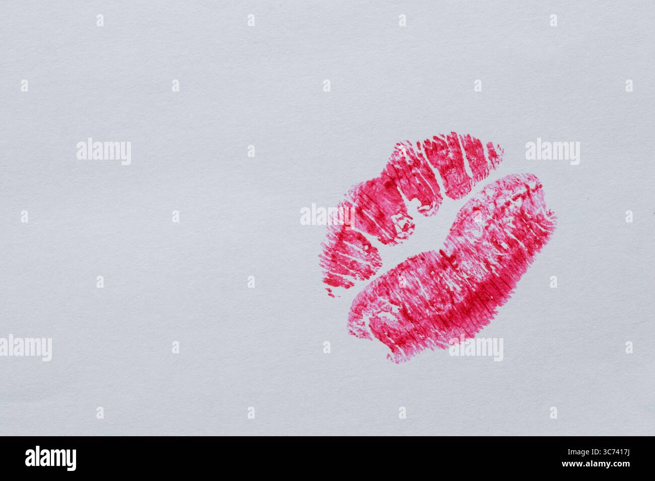Bright lip imprint with red lipstick on white paper, symbol of kiss and ...
