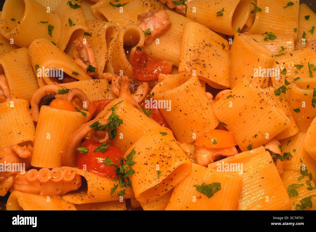 Mezzi Paccheri Pasta With Octopus And Tomatoes Stock Photo - Alamy