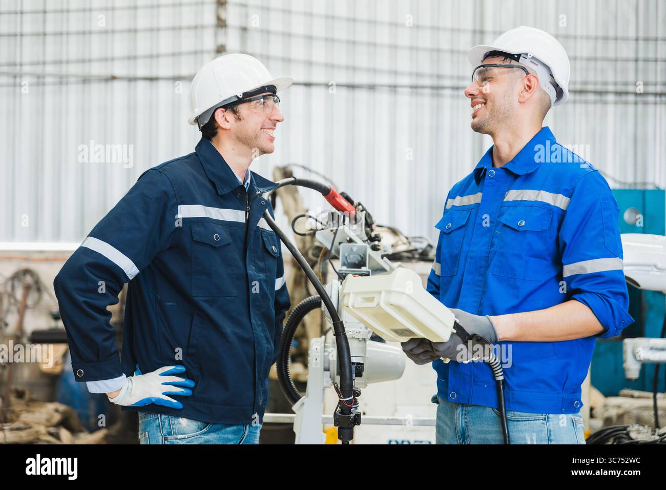 robotics engineers checking a robot arm in an industrial factory Stock ...