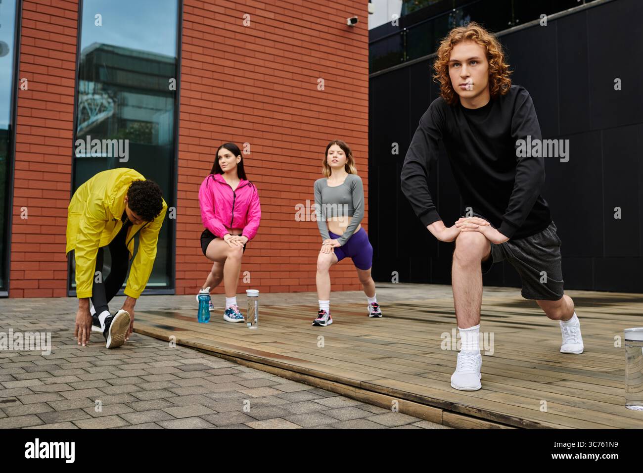Four dynamic individuals partake in stretching exercises as they ...