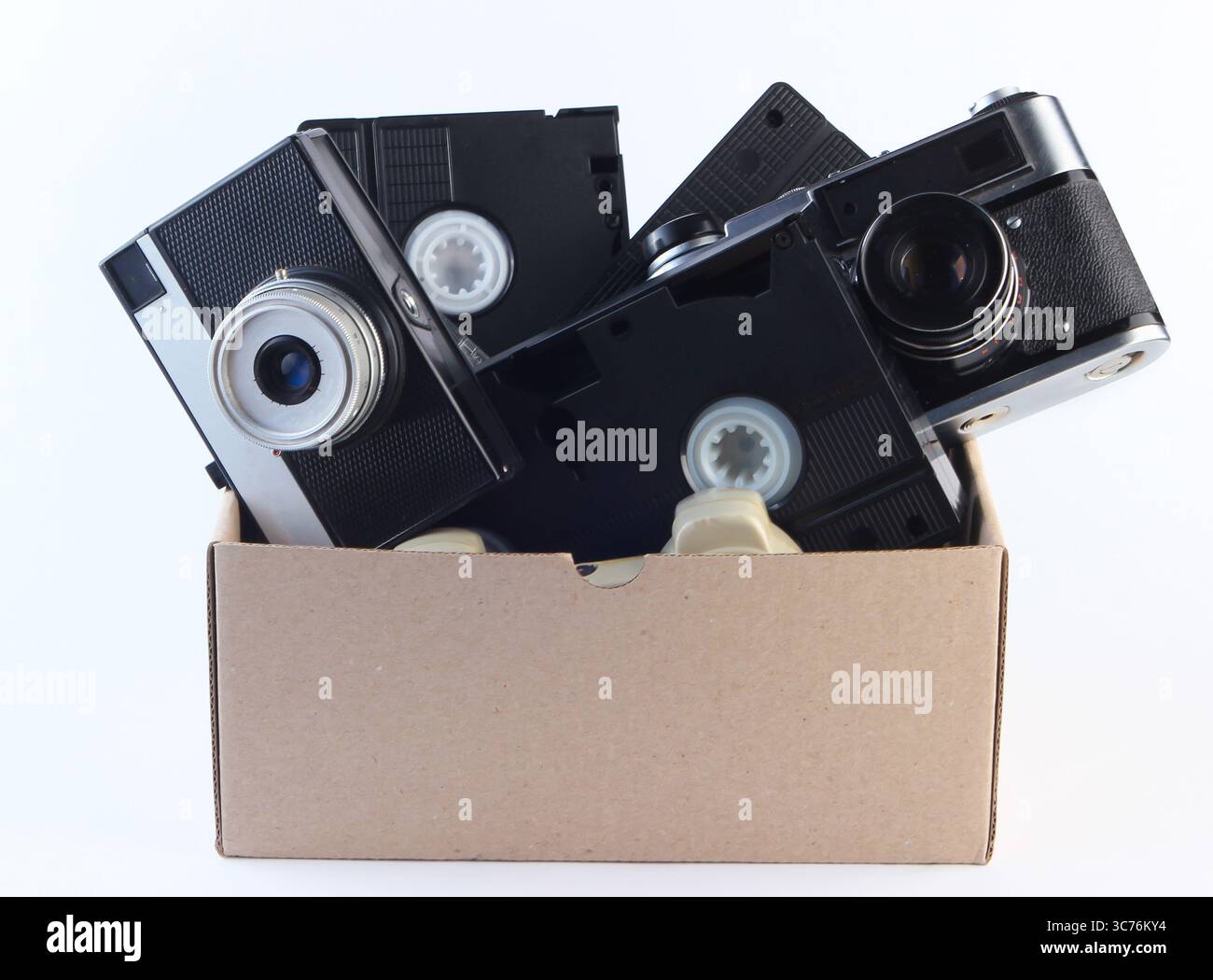 Cardboard box with video cassettes and retro film camera on a white ...