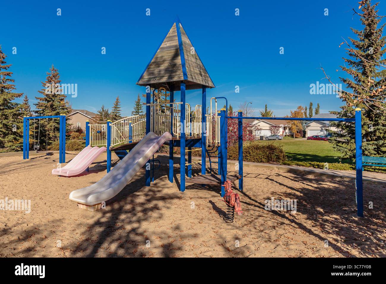 Playground with a blue structure and a white slide. The playground is ...