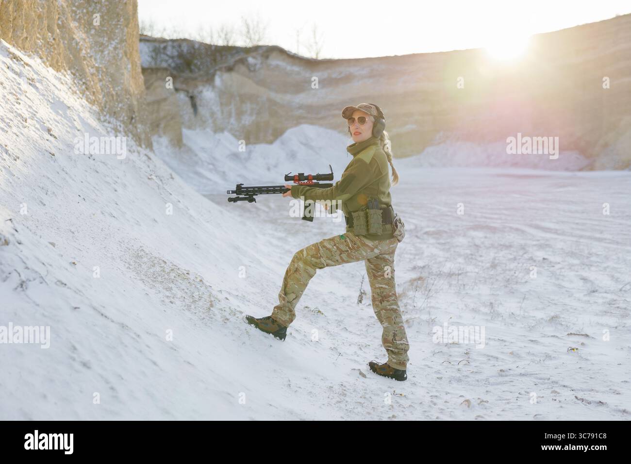 Female soldier reloading her rifle during a winter military training ...