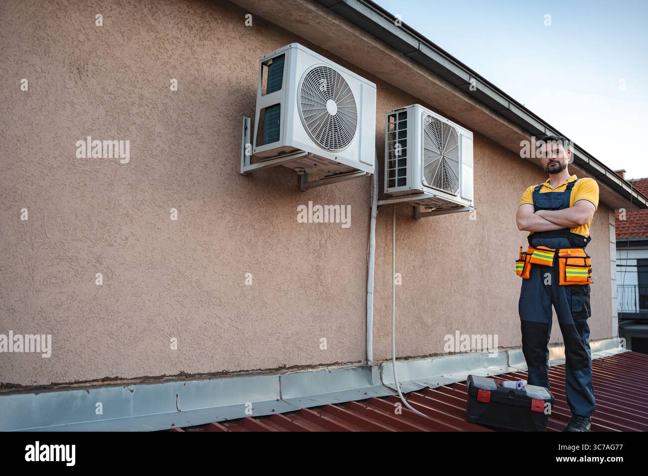 HVAC technician standing on roof next to air conditioning units Stock ...