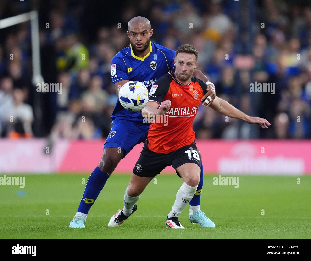 Luton Town's Jordan Clark (right) and AFC Wimbledon's Ryan Johnson ...
