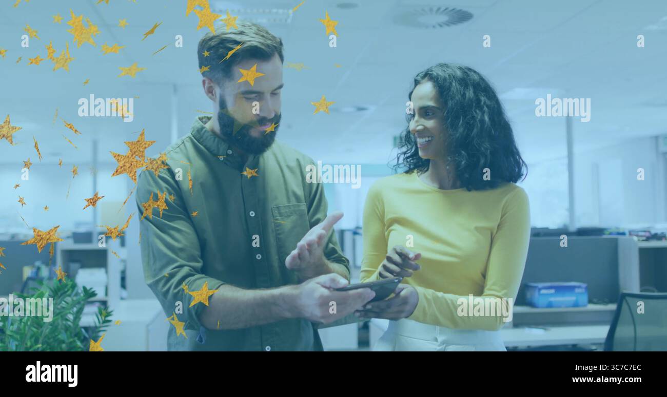 Two coworkers reviewing tablet screen in open-plan office, with ...