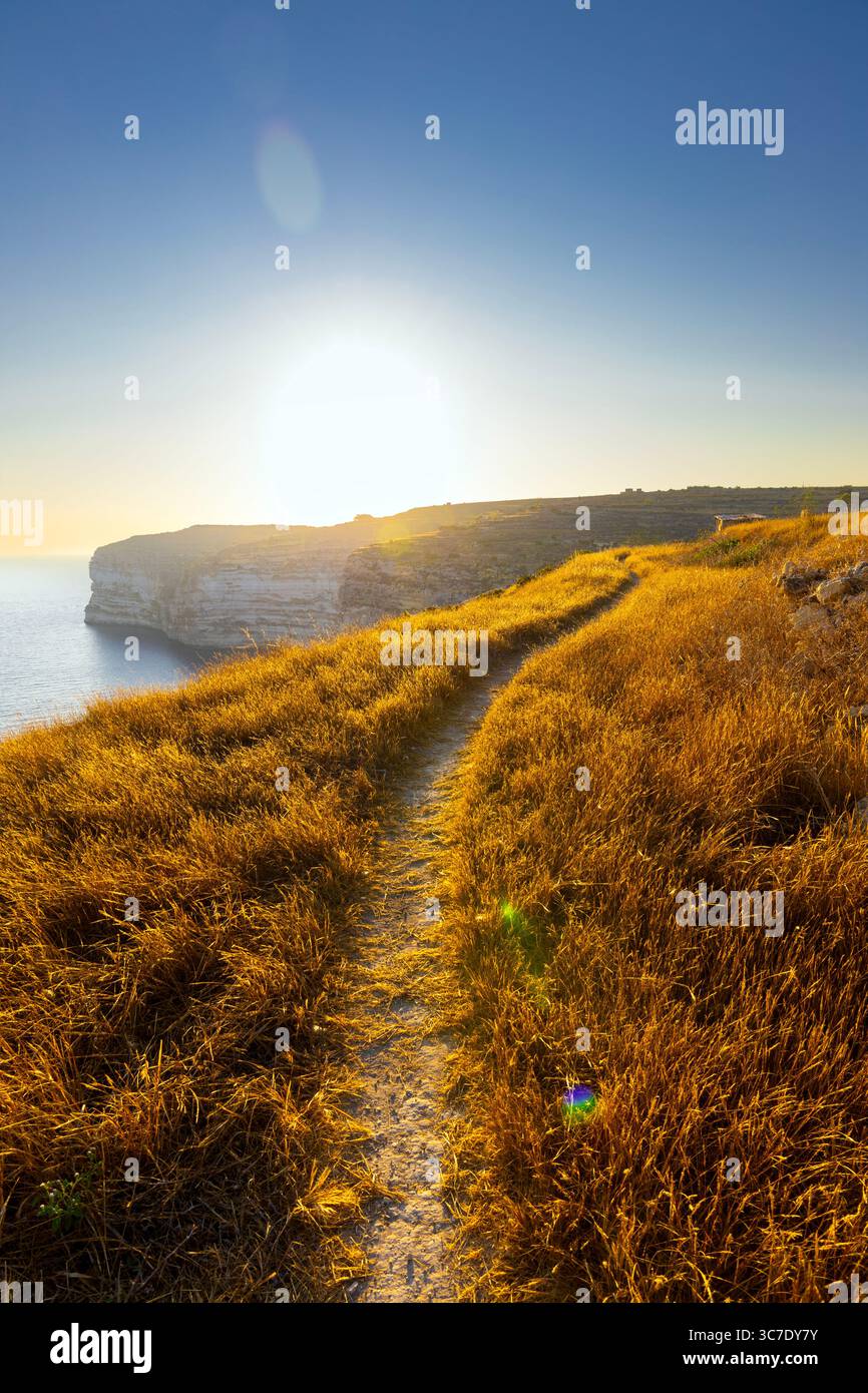 Coastal hiking path along the Xlendi cliffside at sunset, Gozo, Malta ...