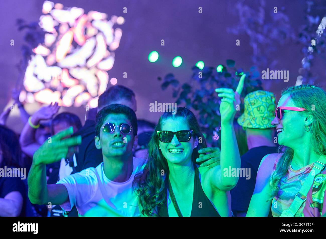 01 August 2025, Rhineland-Palatinate, Kastellaun: Techno fans dance on ...