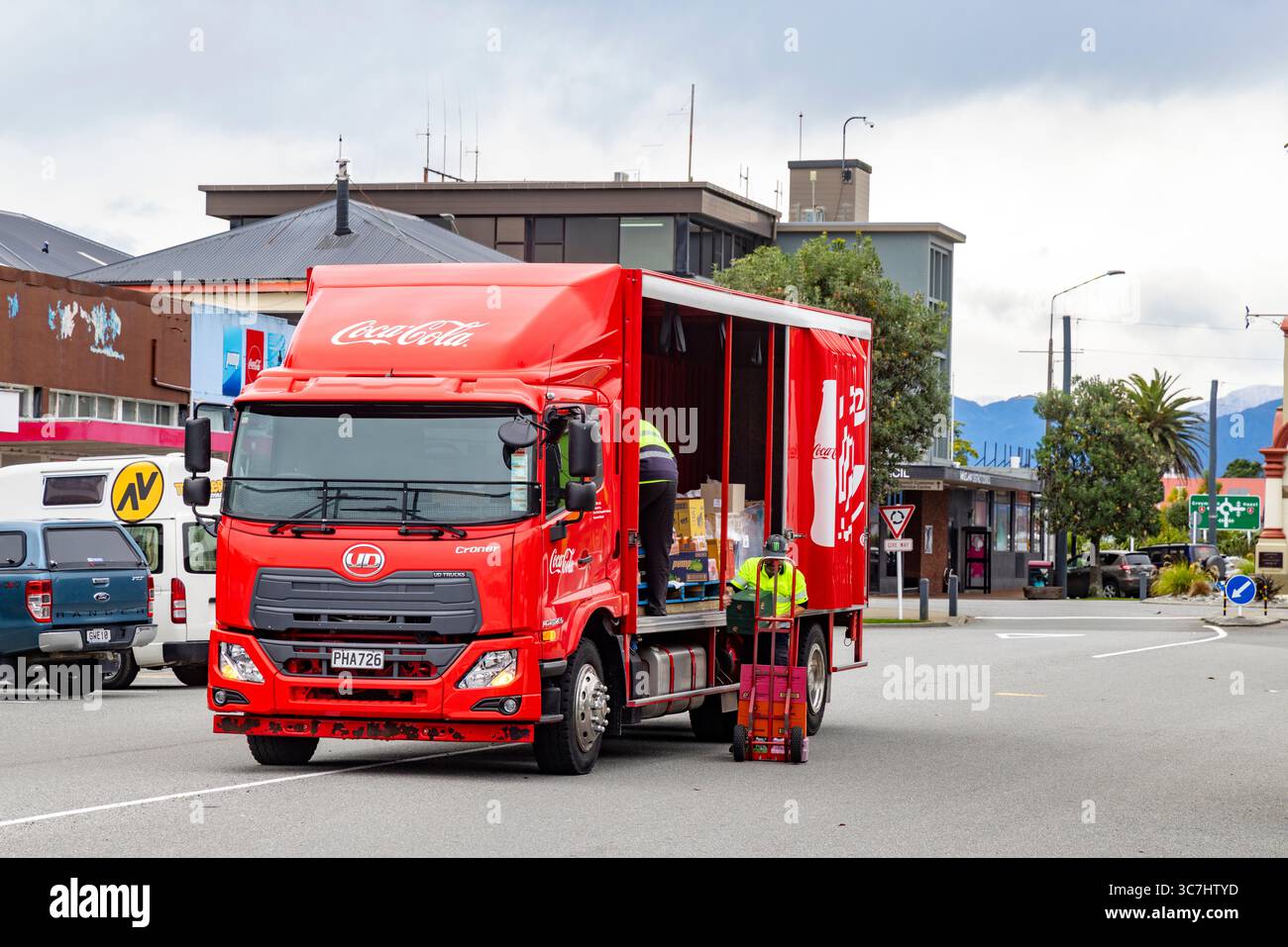 Coca Cola truck delivery of drinks, two employees drivers unloading ...