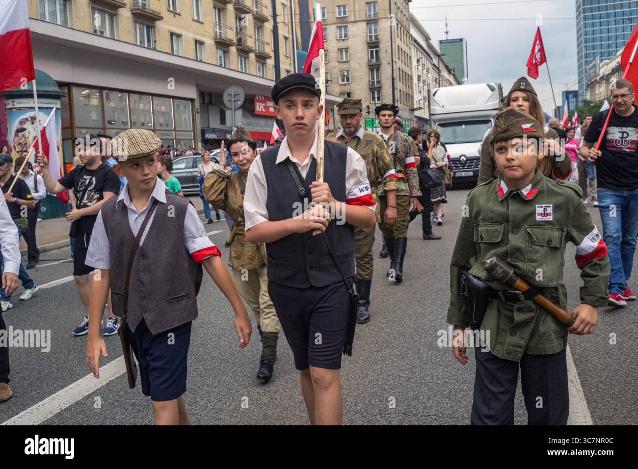 Children dressed in costumes march with flags during the commemoration ...