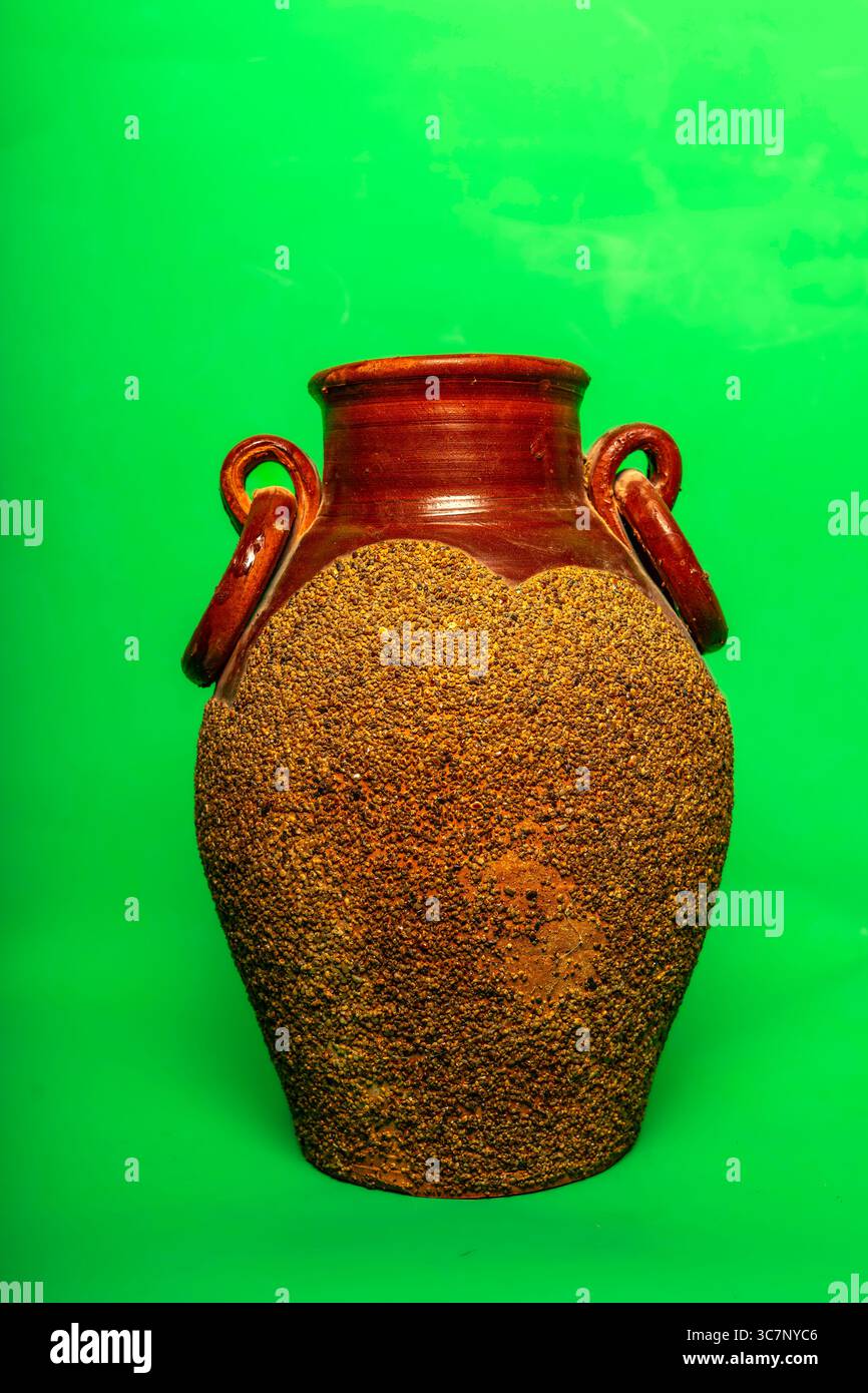 A traditional handcrafted clay water jar with a rough textured surface ...