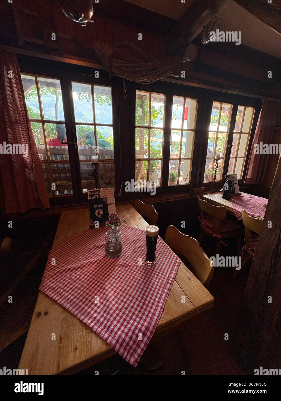 Cozy interior of traditional alpine restaurant with beer on rustic ...