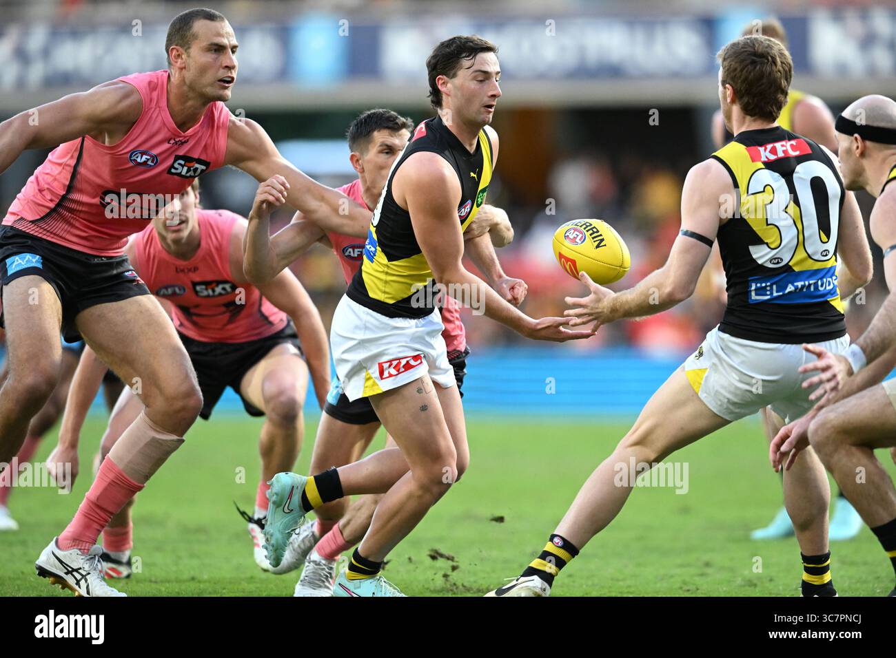 Tyler Sonsie (centre) of the Tigers handballs during the AFL Round 21 ...