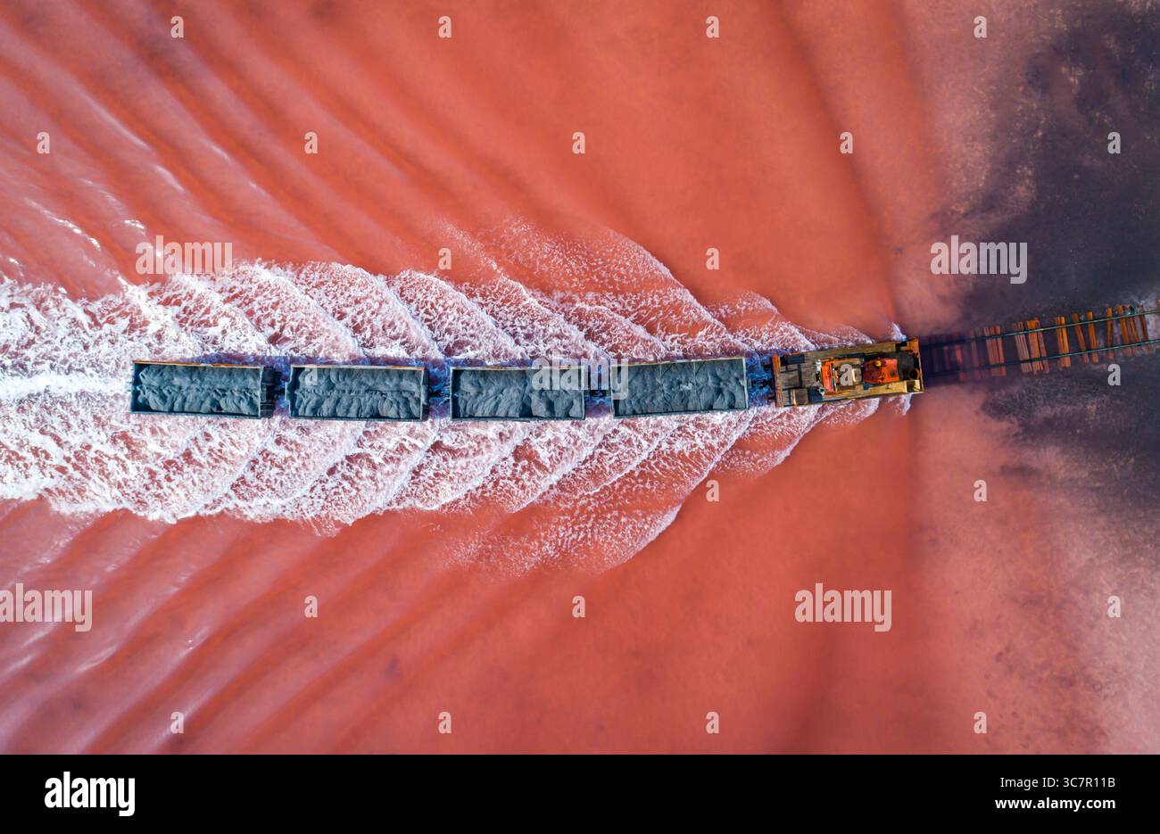 Aerial view of an old train rides on the railway laid in the water ...