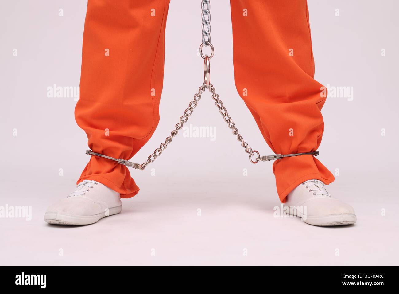 female prisoner in leg irons and orange overalls Stock Photo - Alamy