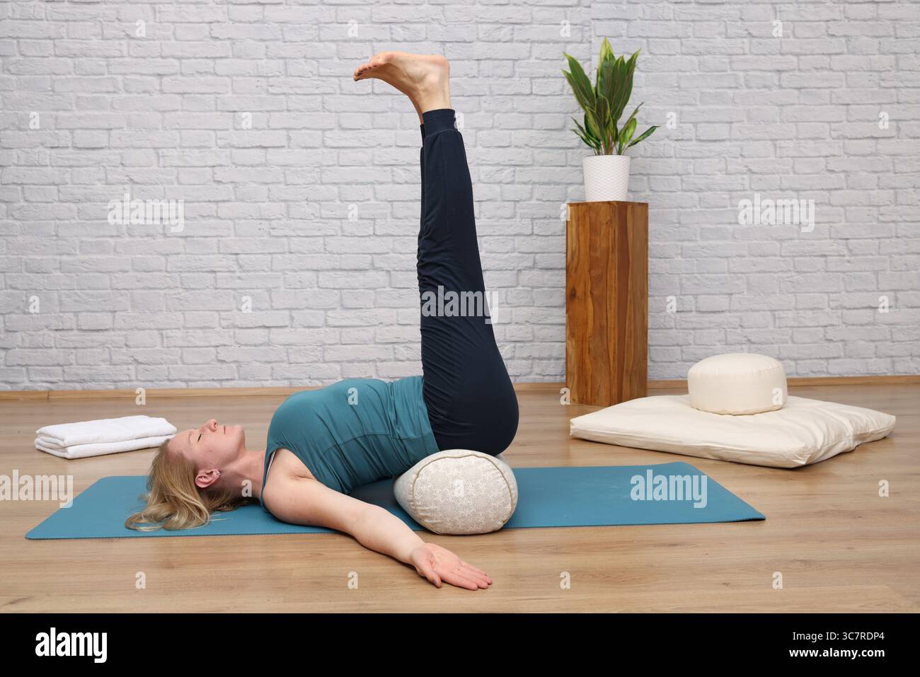 Woman doing yoga in yoga studio - supported shoulder stand Stock Photo ...
