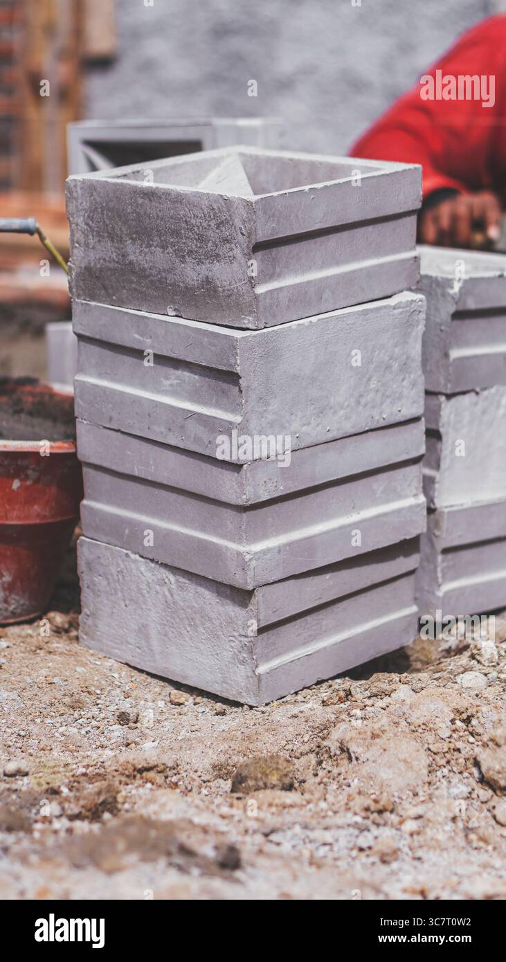 A construction worker carefully installs ventilation blocks, creating ...