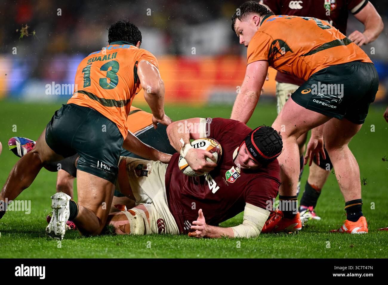 James Ryan of the Lions is tackled by Joseph-Aukuso Suaalii (left) and ...