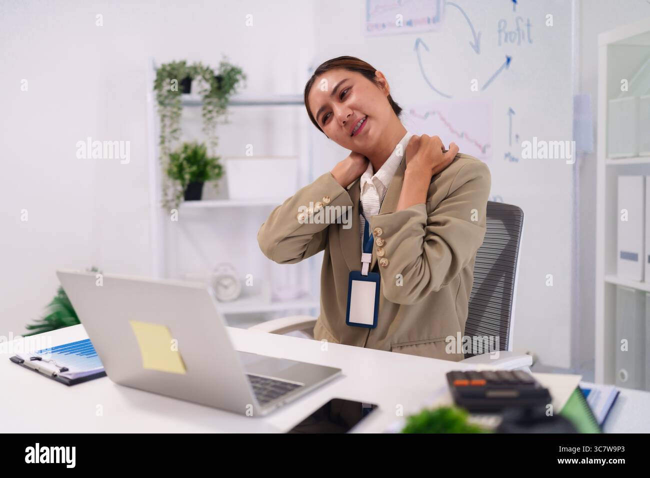 Asian female professional takes well deserved break stretching neck ...