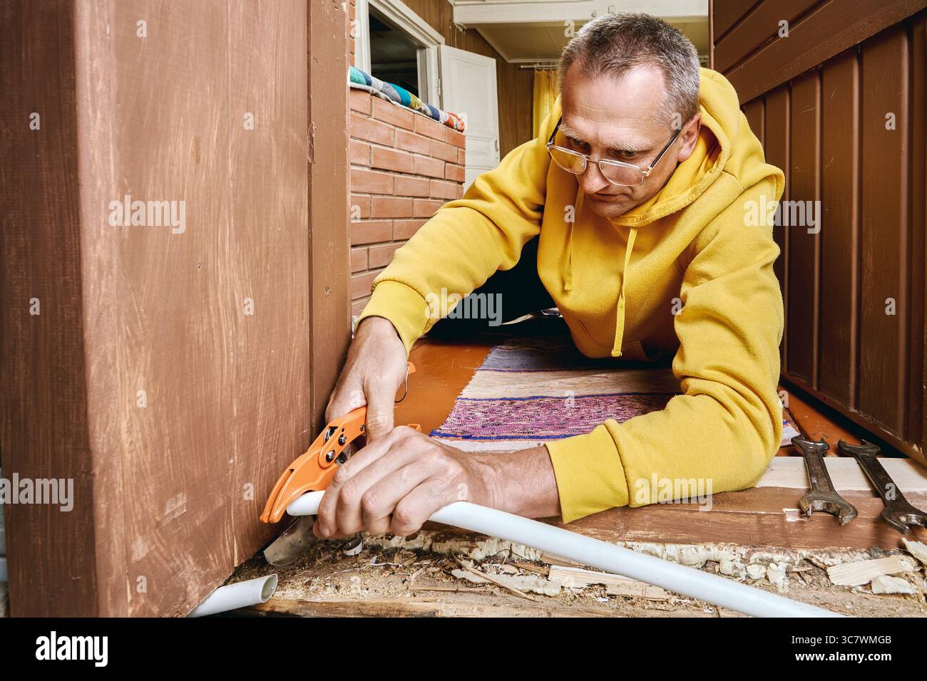 Pipe is being cut with ratchet cutter by plumber to prepare clean edge ...
