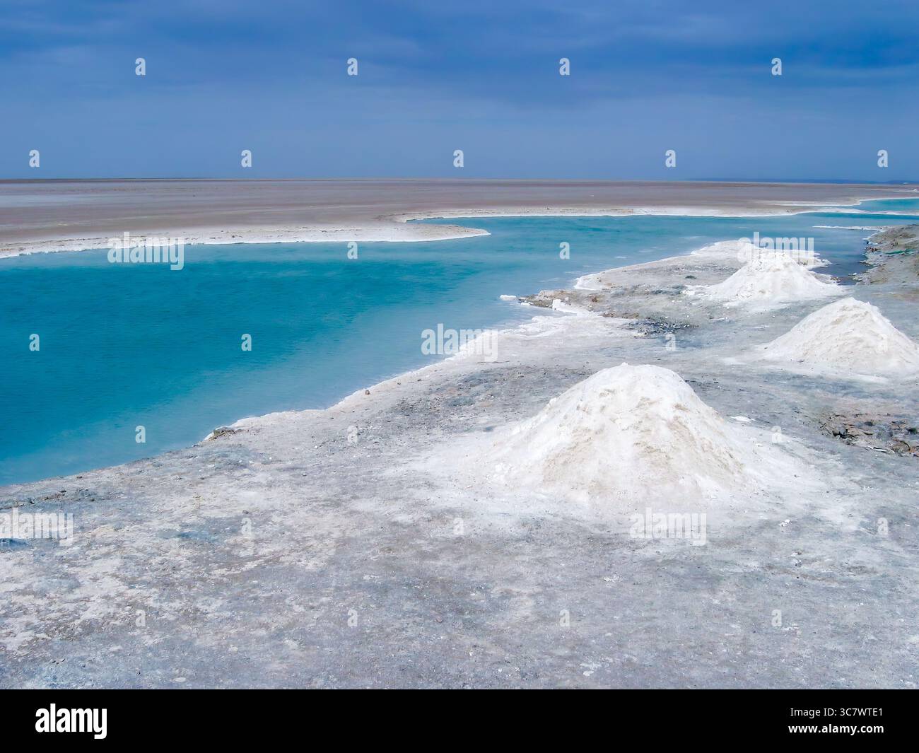 Evaporated salt formations rise beside turquoise pools, creating a ...