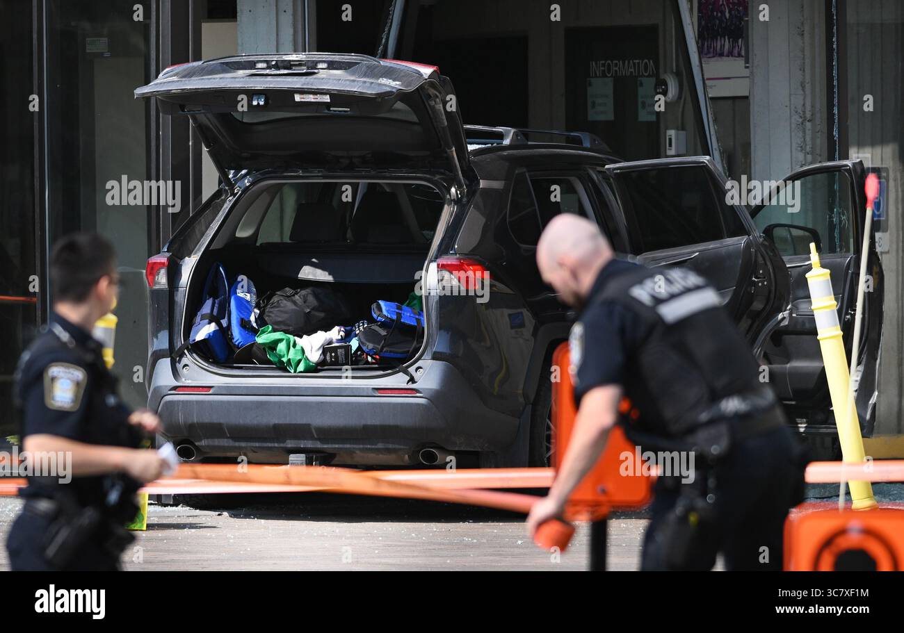 Police at the scene next to a car that crashed into the entrance to the ...