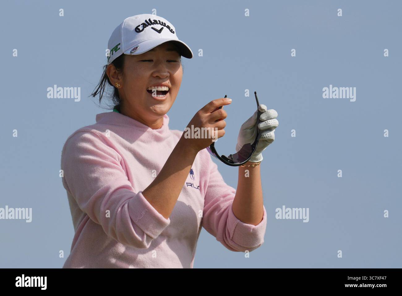 Andrea Lee of the United States takes her sunglasses after playing off ...