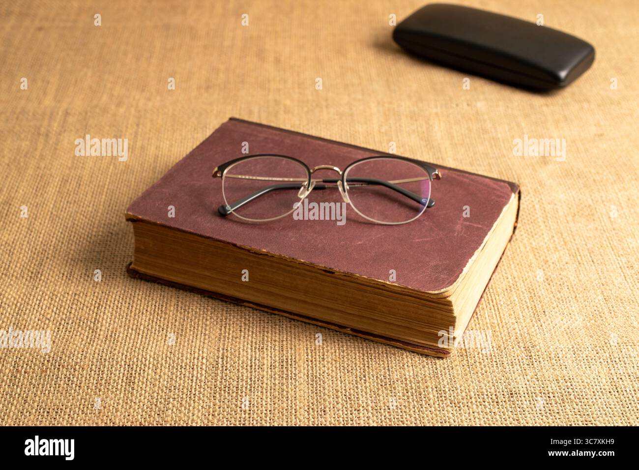 One old book with glasses on jute cloth, close-up Stock Photo - Alamy