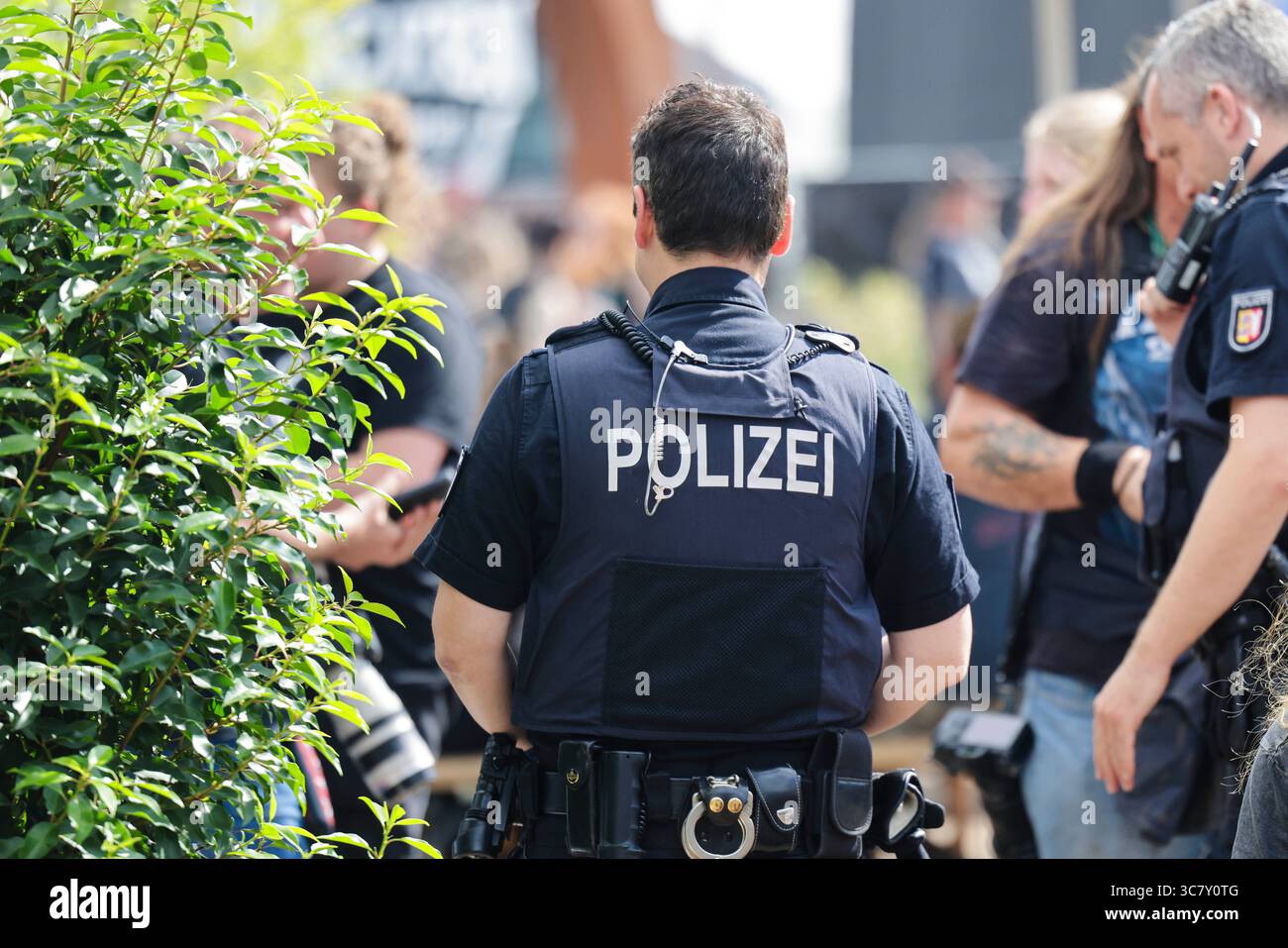 02 August 2025, Schleswig-Holstein, Wacken: Police officers talk to ...