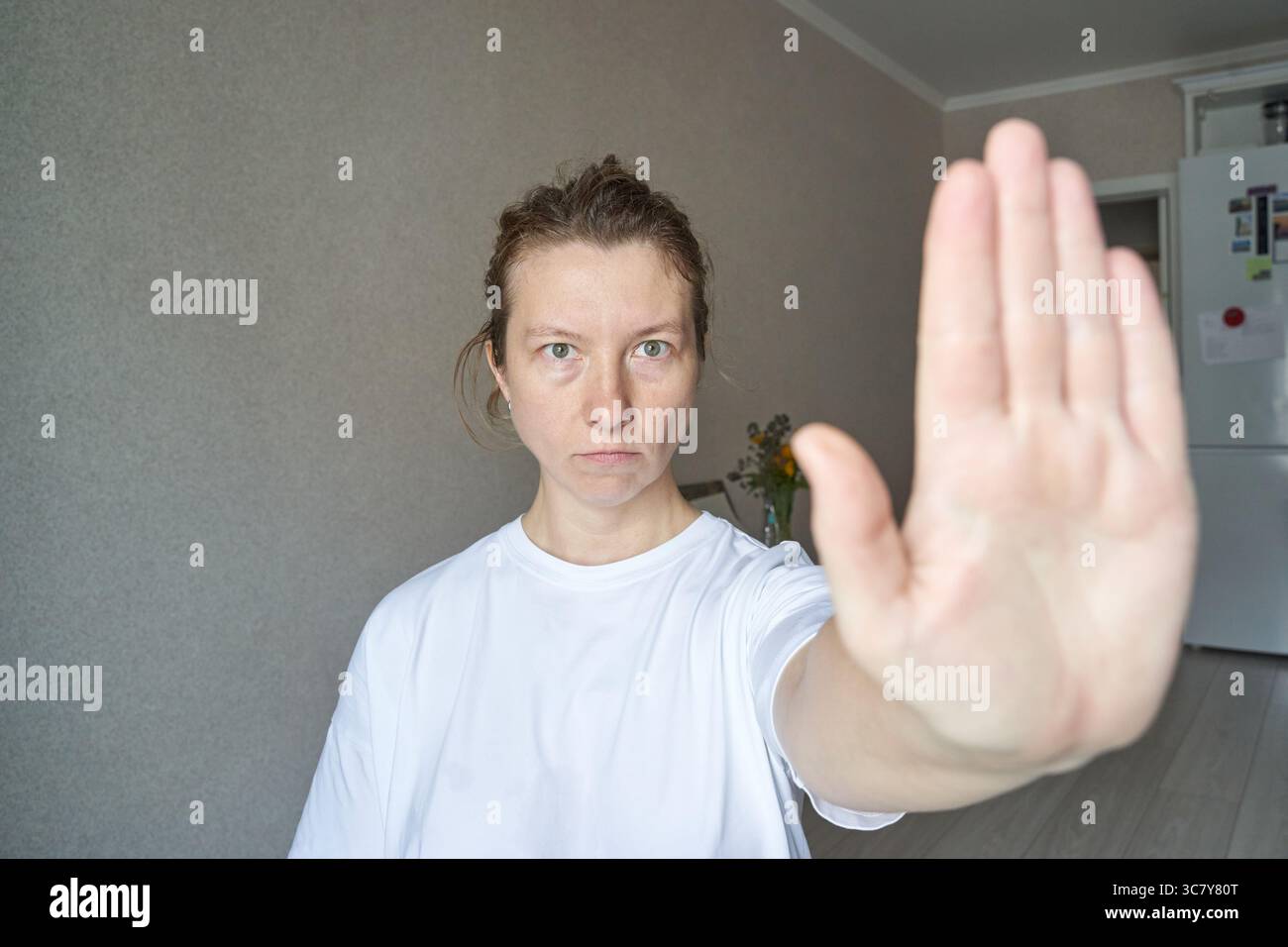 Caucasian female adult showing stop gesture with hand in indoor setting ...