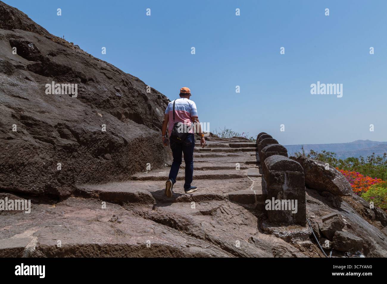 A elderly tourist man walking on the steps of Shivneri fort, Junnar ...