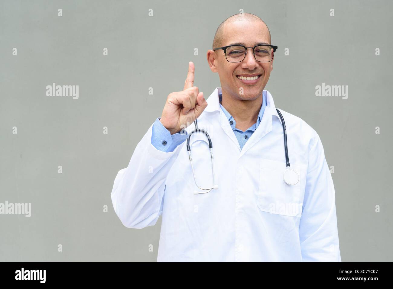 Portrait of mature bald male doctor wearing lab coat and eyeglasses ...